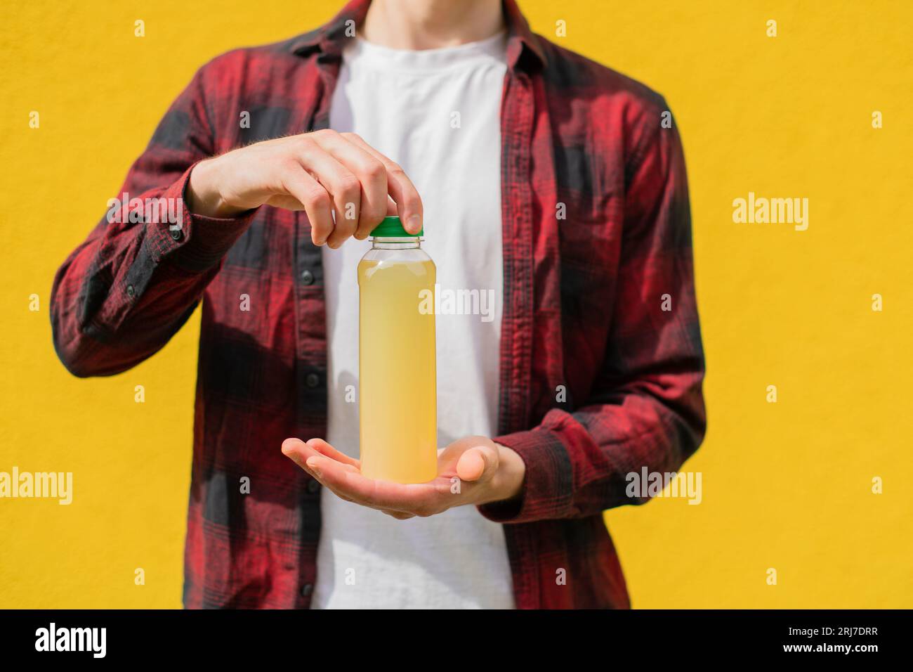 Close-up hand of unrecognizable man in red shirt holding Orange ...