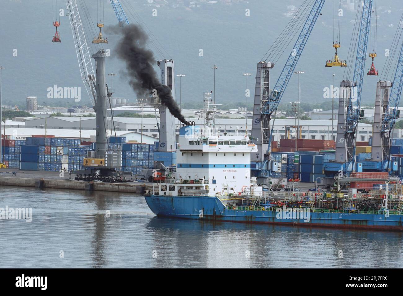 Black smoke as air pollution coming out from funnel of tanker vessel ...