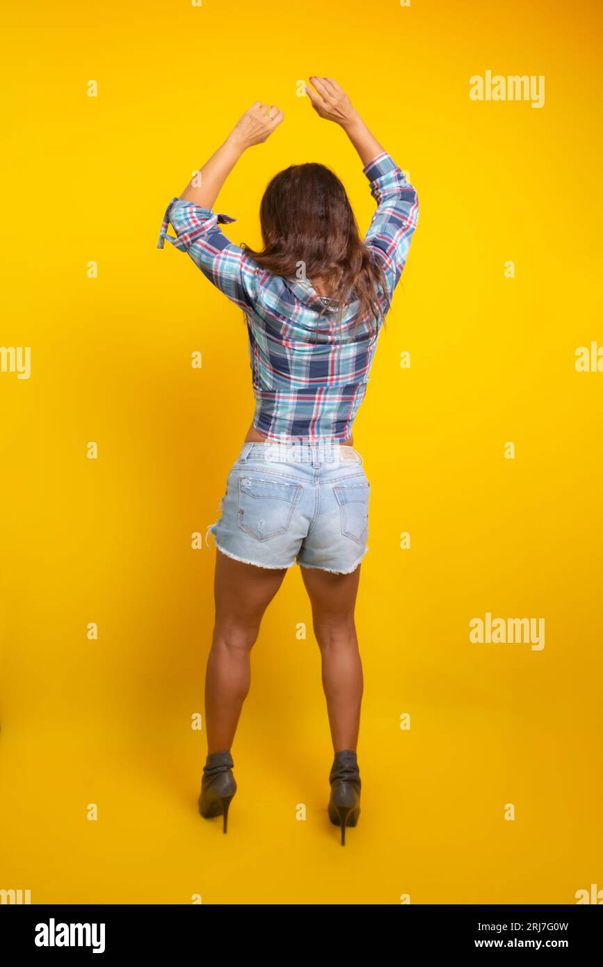 Beautiful mature woman standing with her back to the camera, dressed in ...