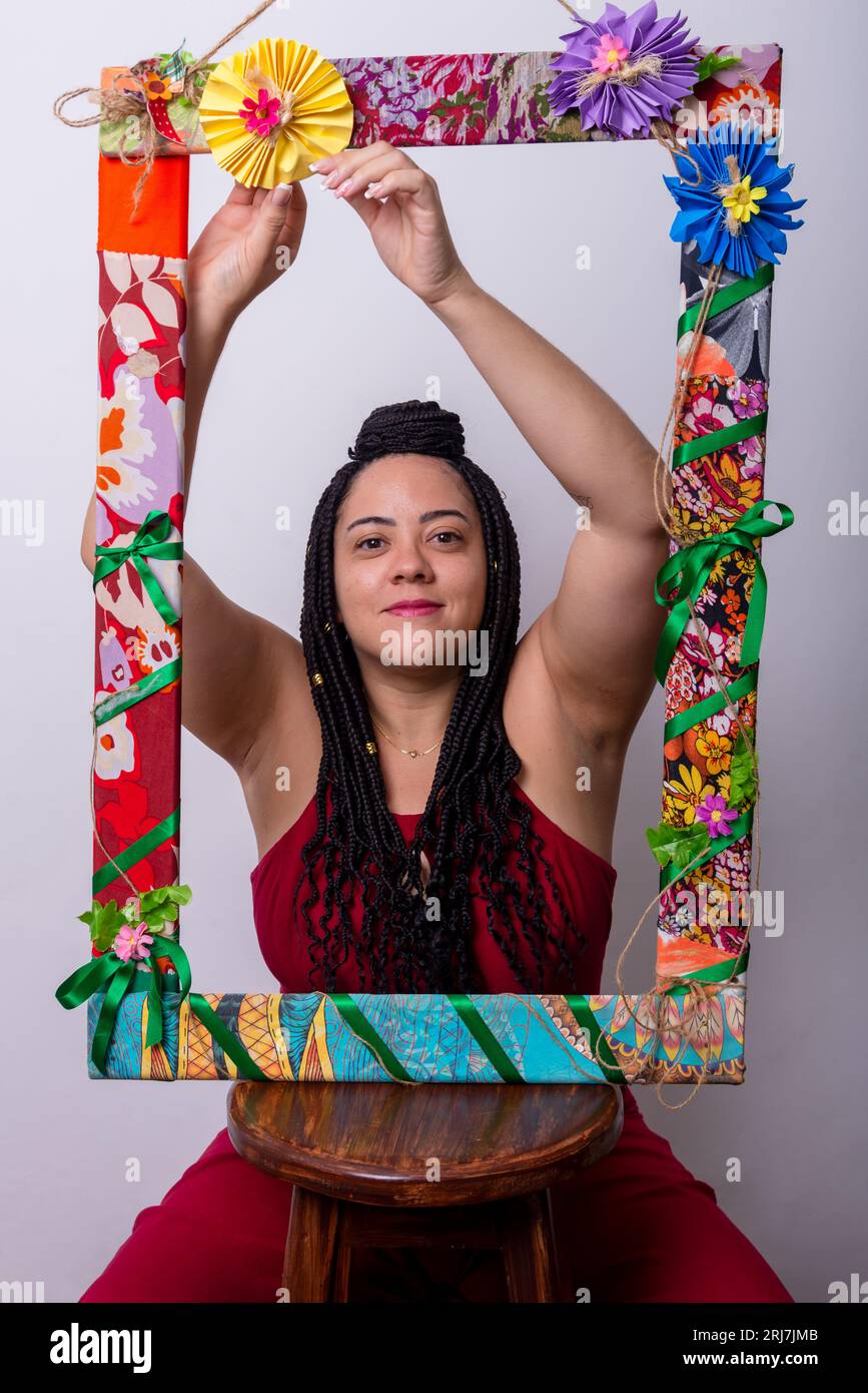 Photo of a beautiful woman behind a frame adorned with flowers and ...