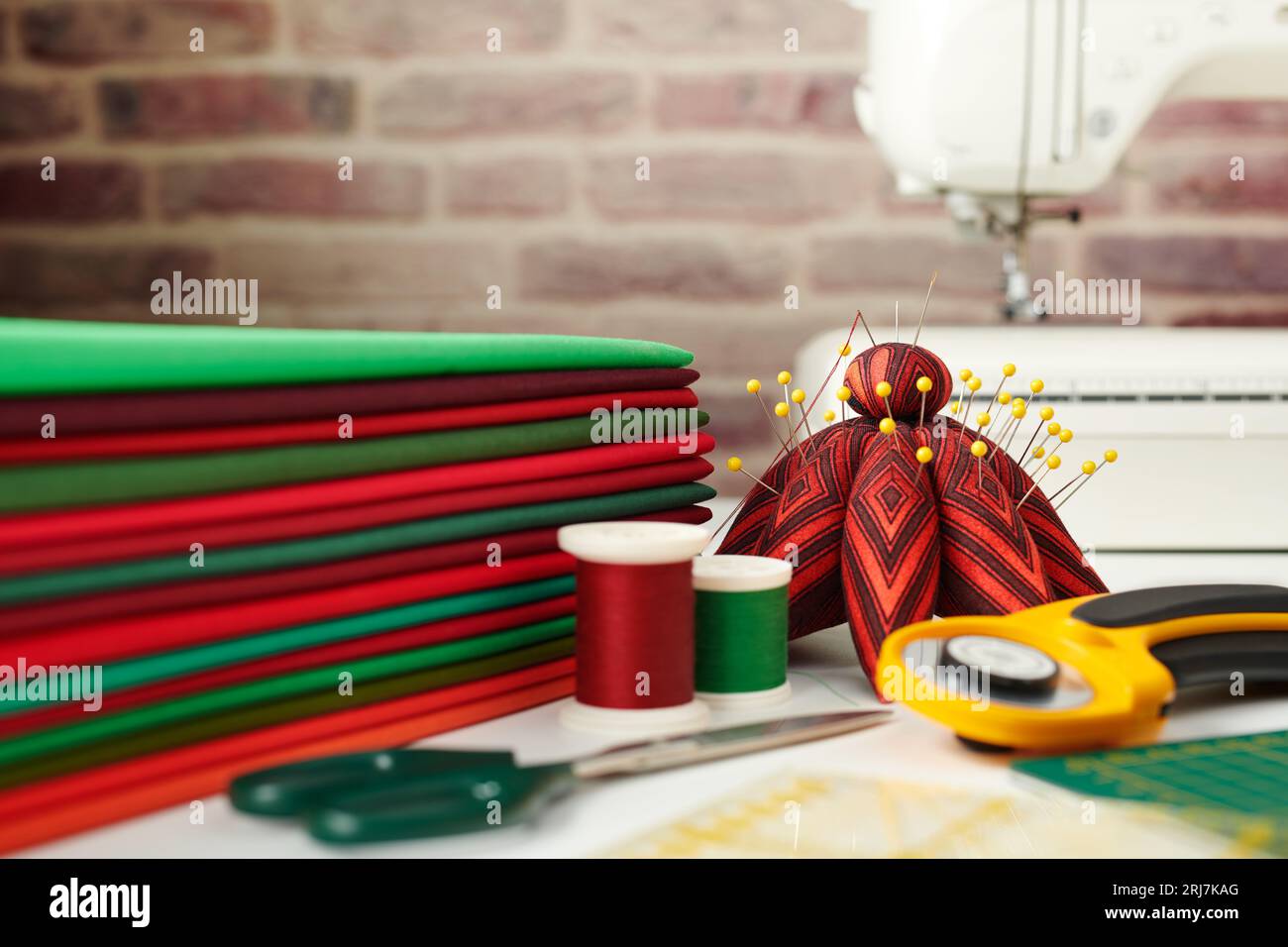 Stack of red and green fabrics, sewing and quilting accessories and ...