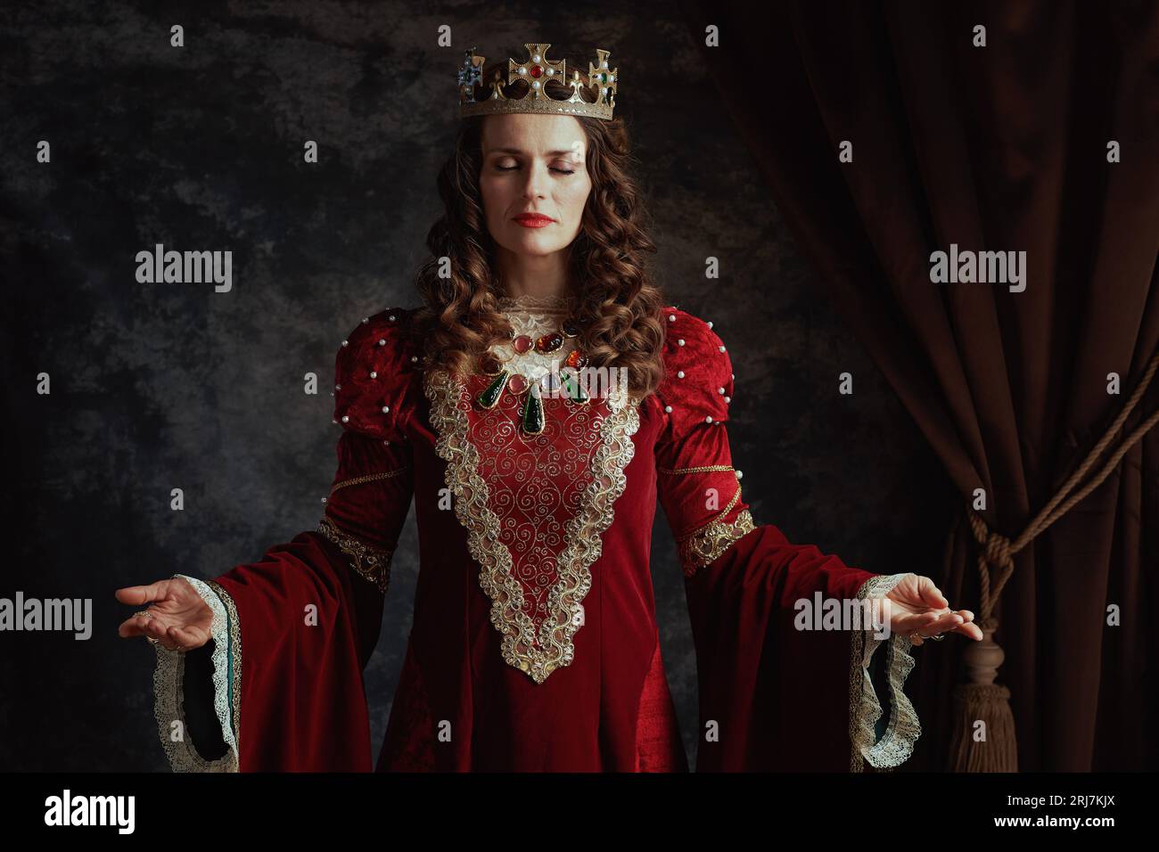 medieval queen in red dress with crown on dark gray background Stock ...