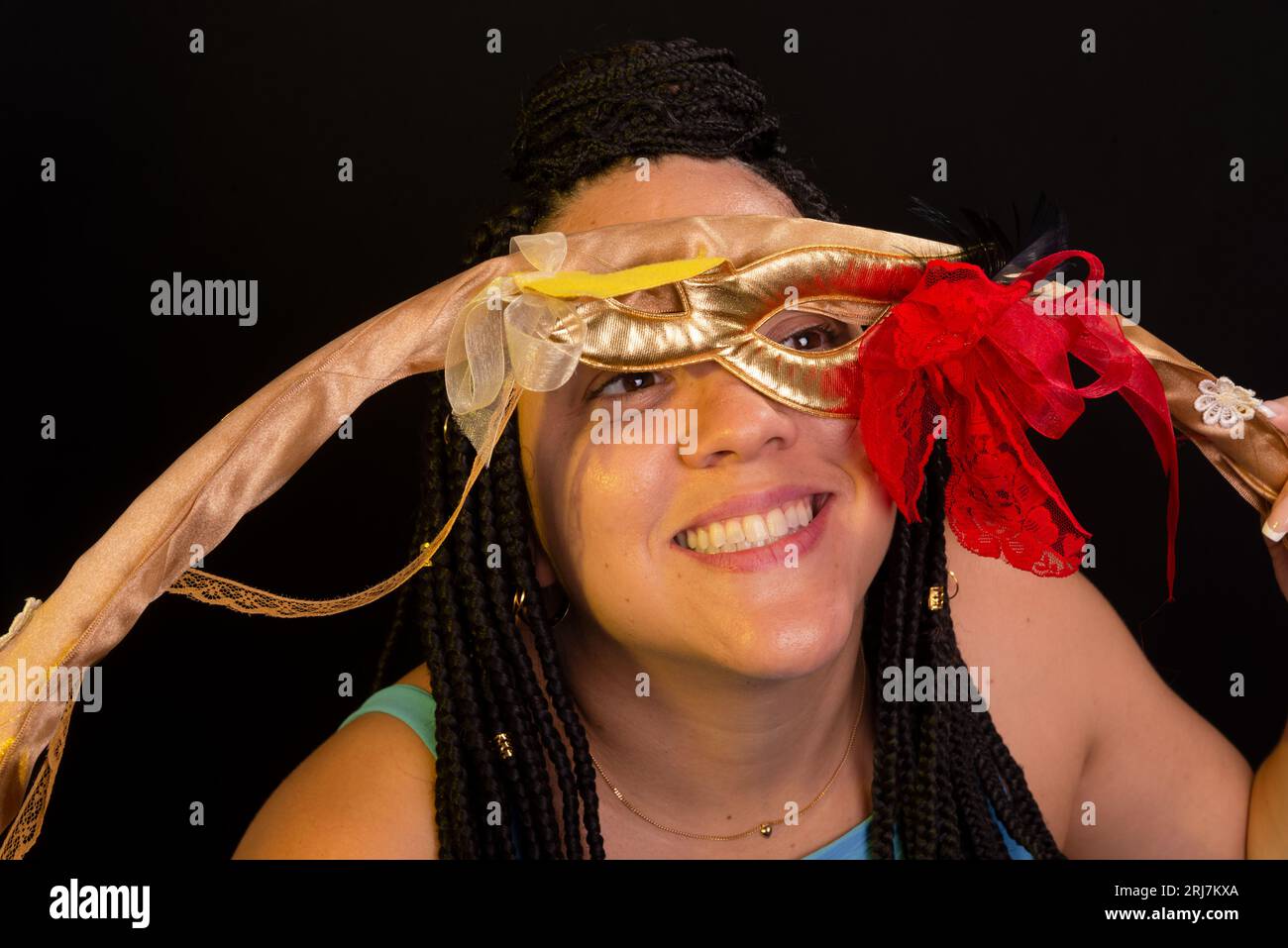 Beautiful woman with braids in her hair putting a mask on her face ...