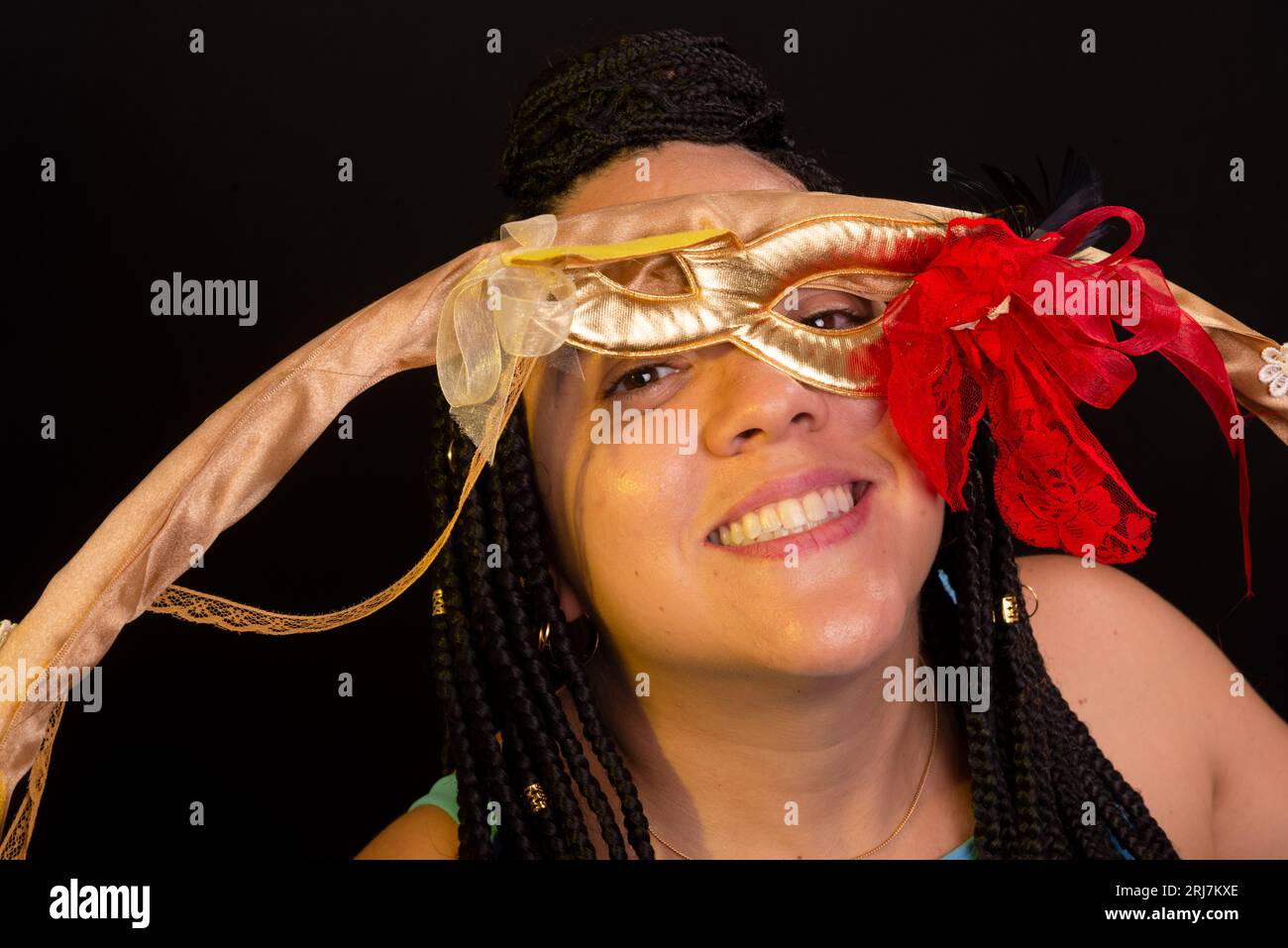 Beautiful woman with braids in her hair putting a mask on her face ...