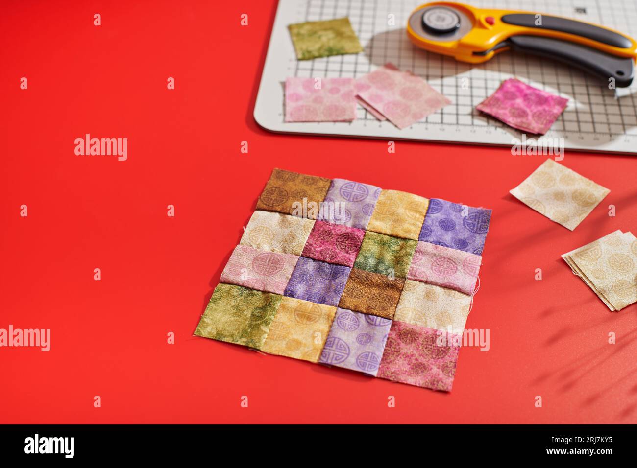 Quilting block from bright square pieces of fabrics, rotary cutter ...