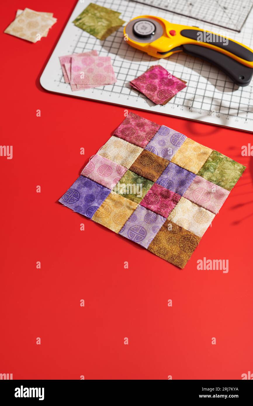 Quilting block from bright square pieces of fabrics, rotary cutter ...