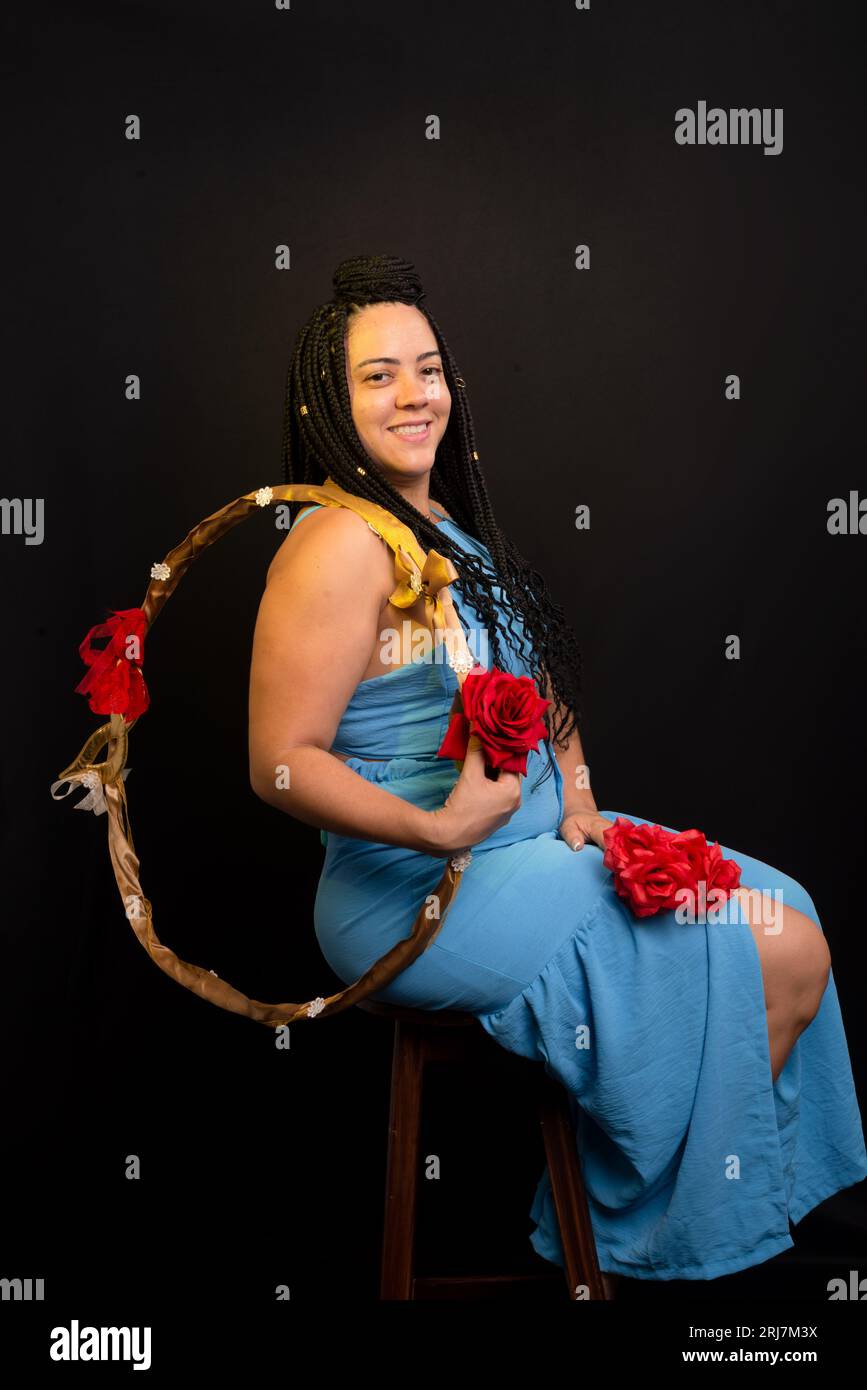 Beautiful woman wearing blue colored outfit sitting holding a hula hoop ...
