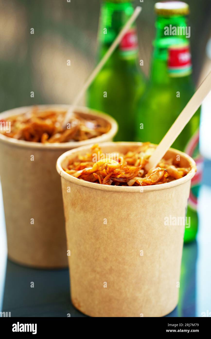 Chinese takeaway food. Wok with noodles and bottles with cold beer ...