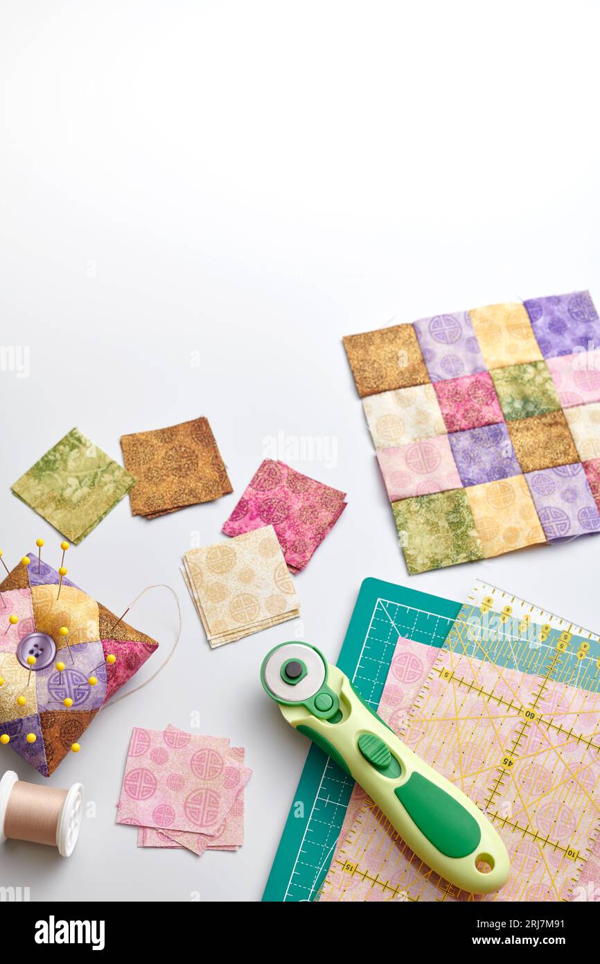 Bright square pieces of fabric, quilting tools, sewing equipment ...