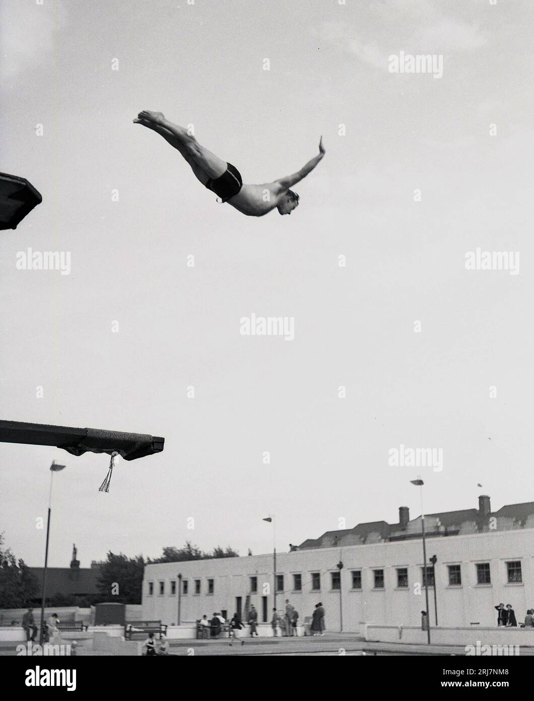 1950s, historical, in mid-air, arms out front, legs and feet together ...