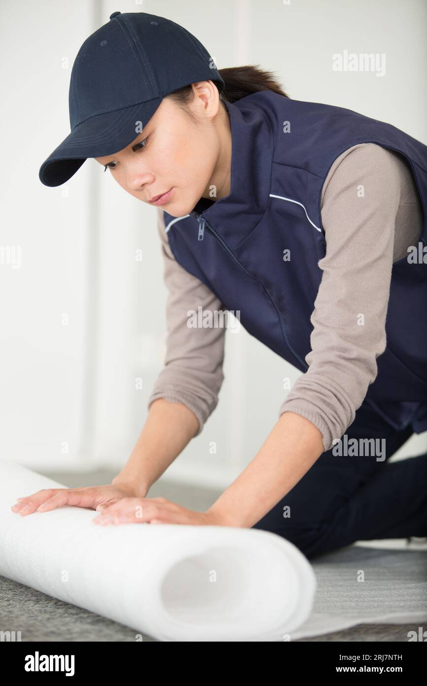female worker unrolling carpet Stock Photo - Alamy