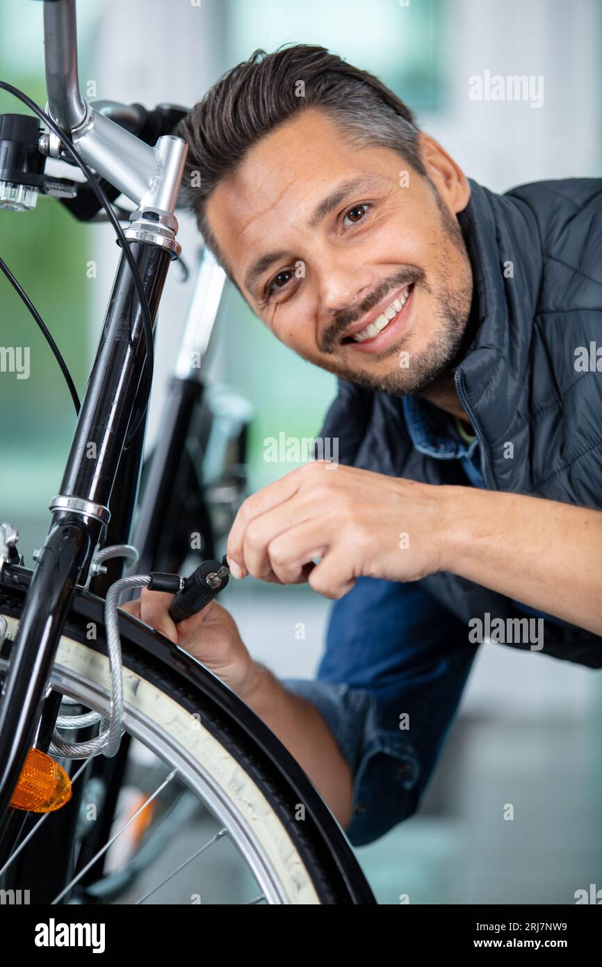 portrait of man locking his bicycle Stock Photo - Alamy