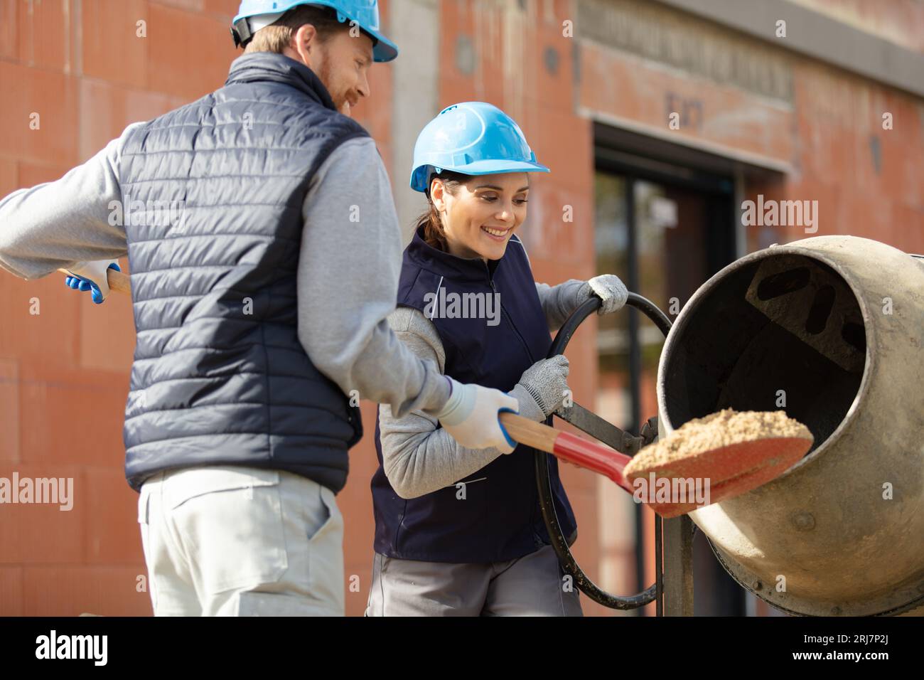 builder couple work with concrete mixe Stock Photo - Alamy