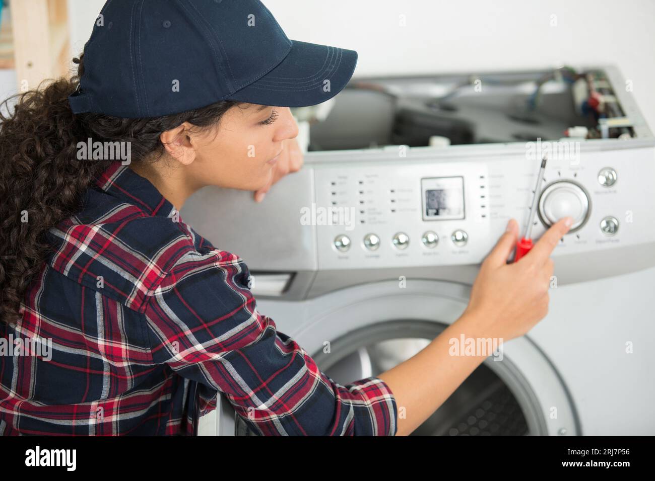 female technician repairing washing machine Stock Photo - Alamy