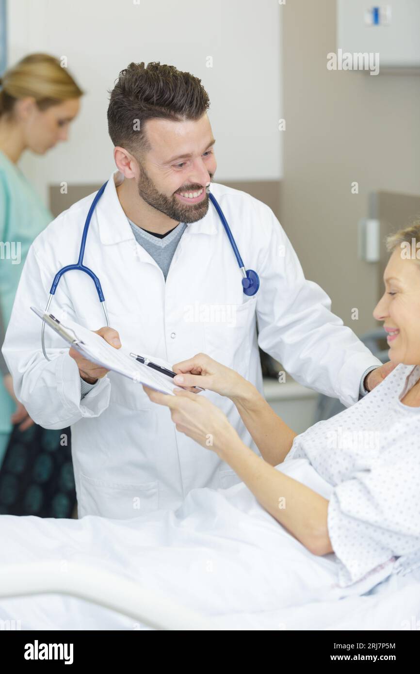 happy female patient signs the medical form Stock Photo - Alamy
