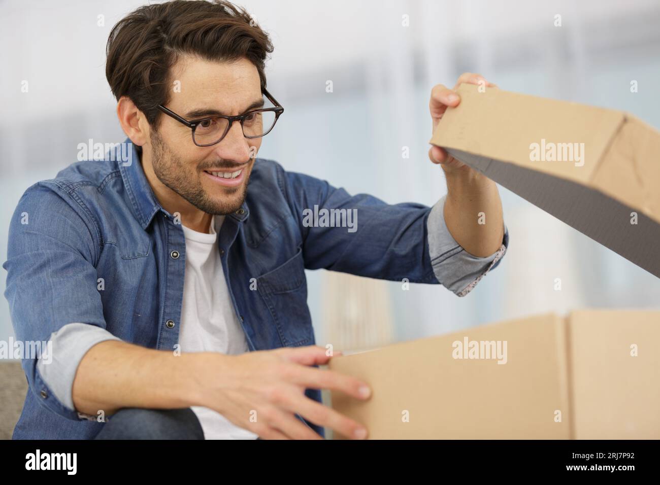 happy man opening parcel box at home Stock Photo - Alamy