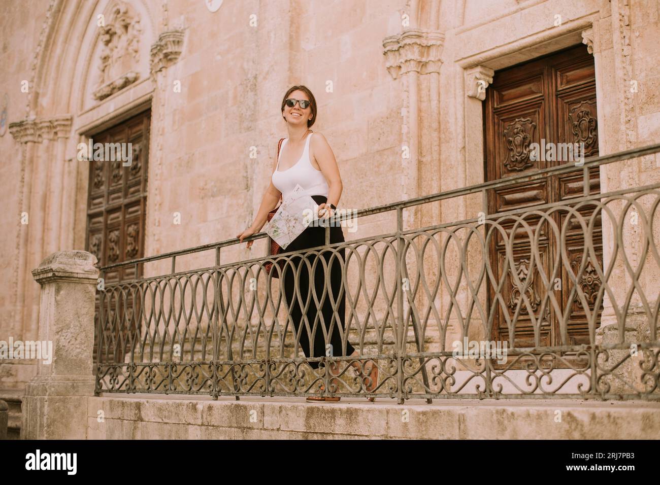 Female tourist with a city map by the church San Francesco d’Assisi in ...