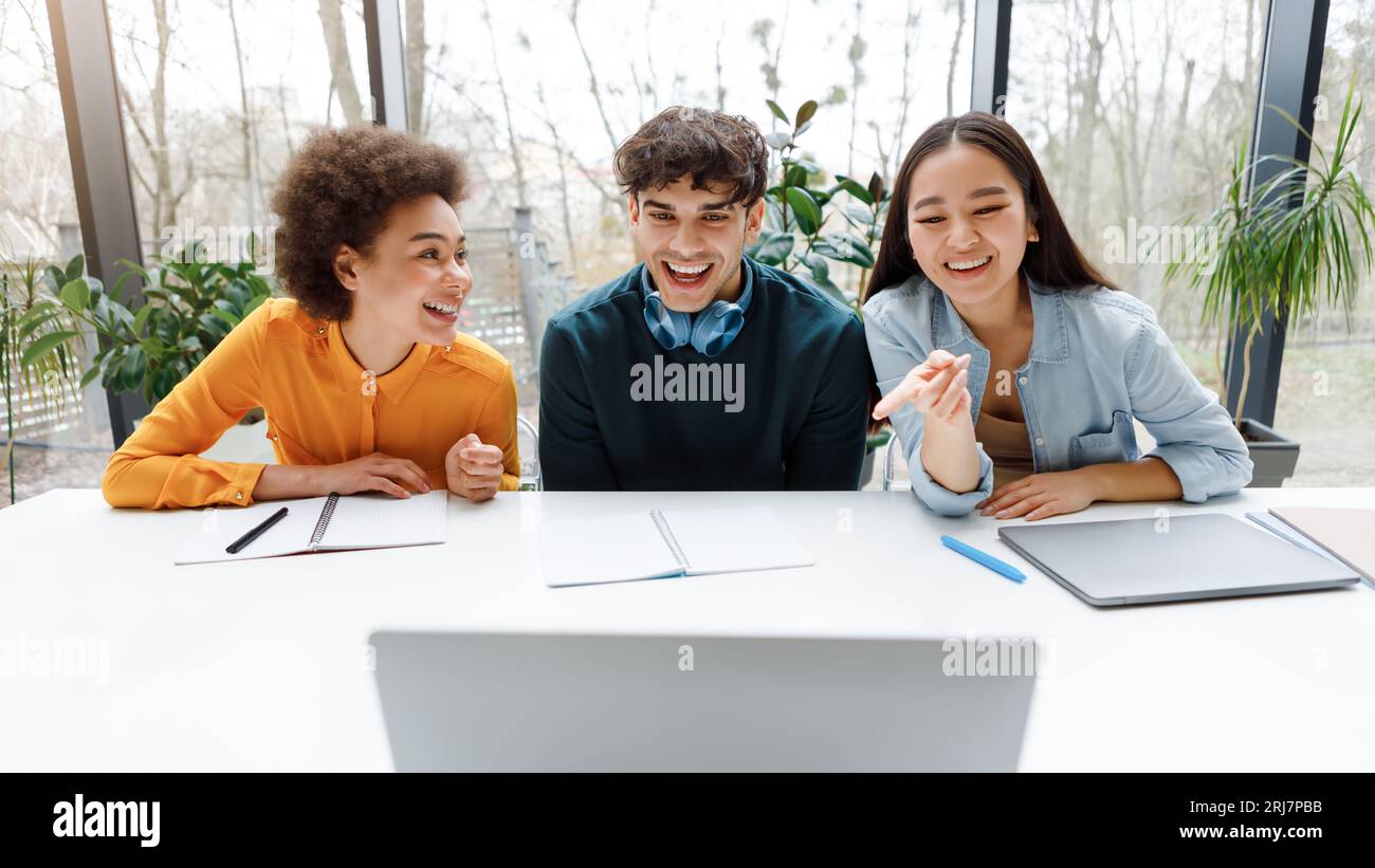 Group of international university students working with laptop, ladies ...
