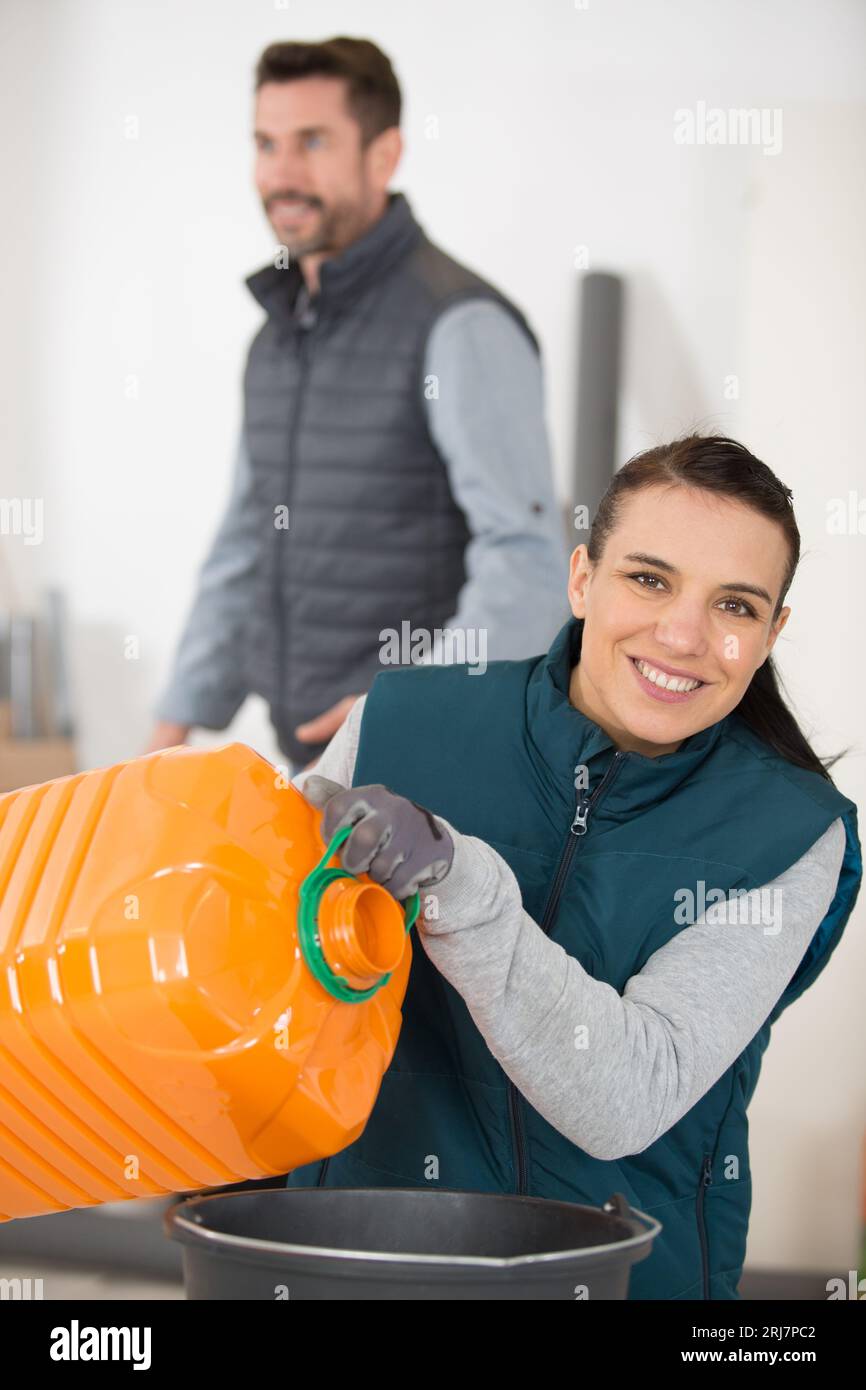 female worker pouring from industrial container Stock Photo - Alamy