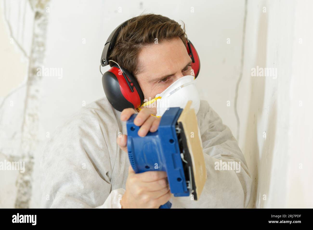 Male builder sanding wall hi-res stock photography and images - Alamy