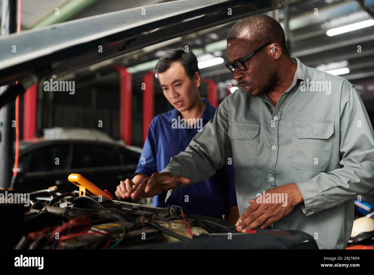 Mechanic using multimeter when checking if engine works good Stock ...