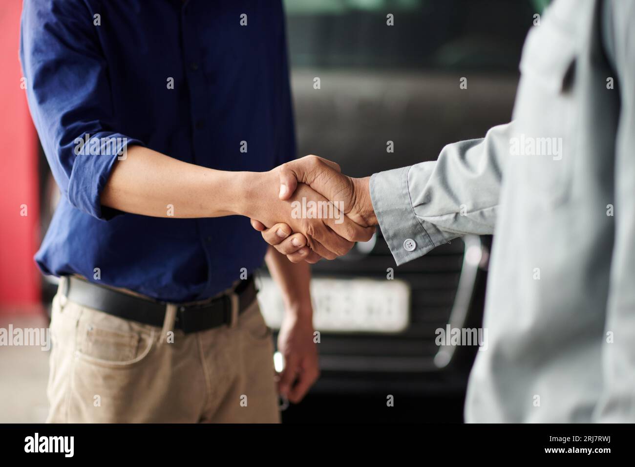 Cropped image of car owner and mechanic shaking hands, greeting each ...