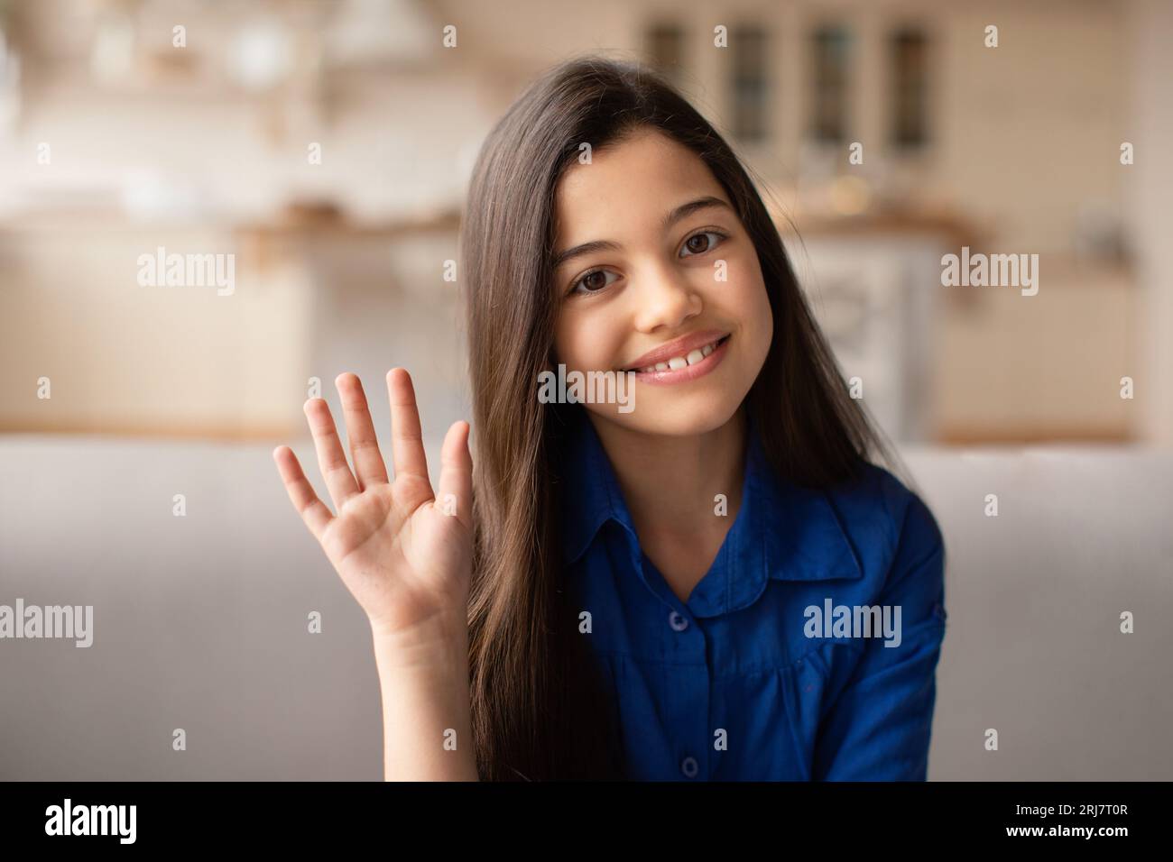 Portrait of cheerful arabic preteen kid girl waving hand indoors Stock Photo - Alamy