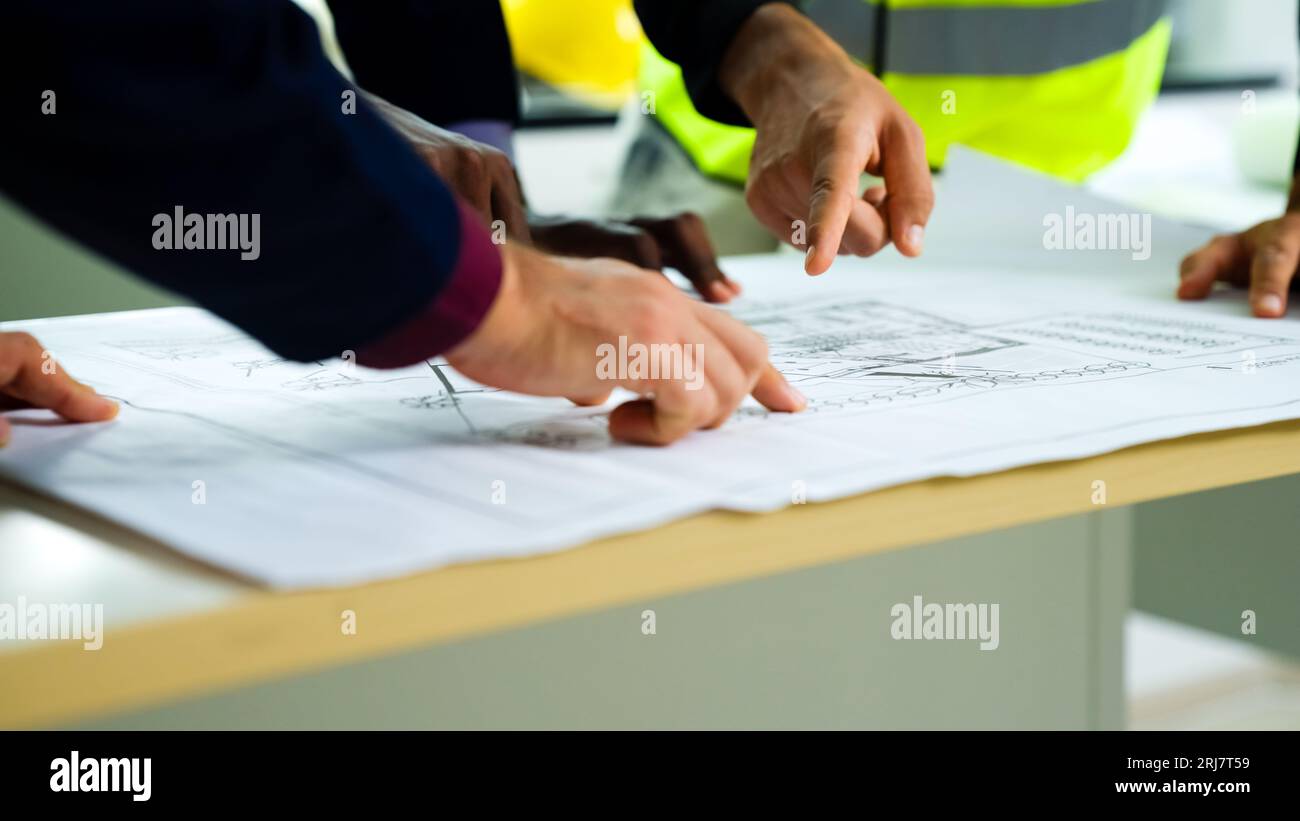 Construction engineers team using blueprint of project plan ...