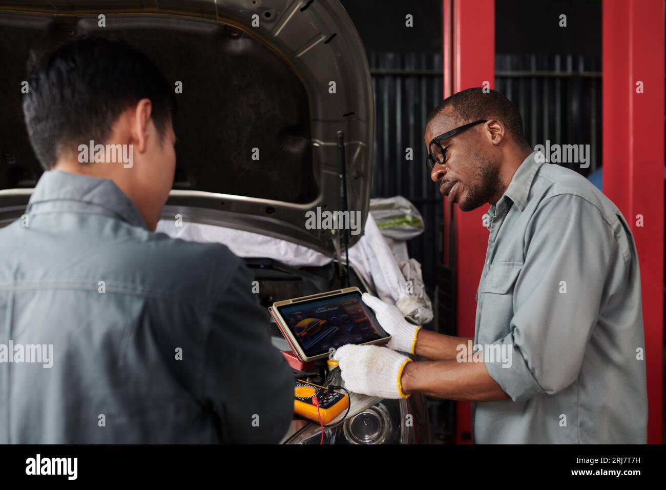 Mechanics using application to check if car parts and engine works good ...