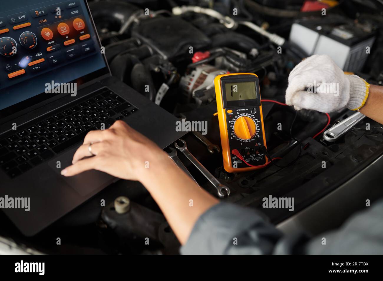 Closeup image mechanic using multimeter when checking work of car ...