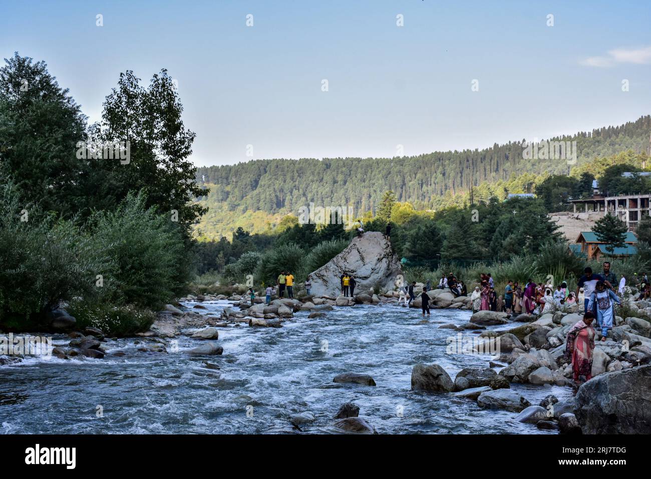 Drung, India. 21st Aug, 2023. Visitors relax near the stream during a ...