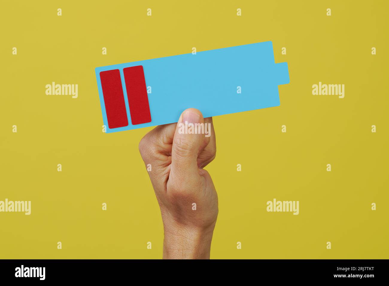 closeup of a man holding a depiction of a battery with a low charge ...