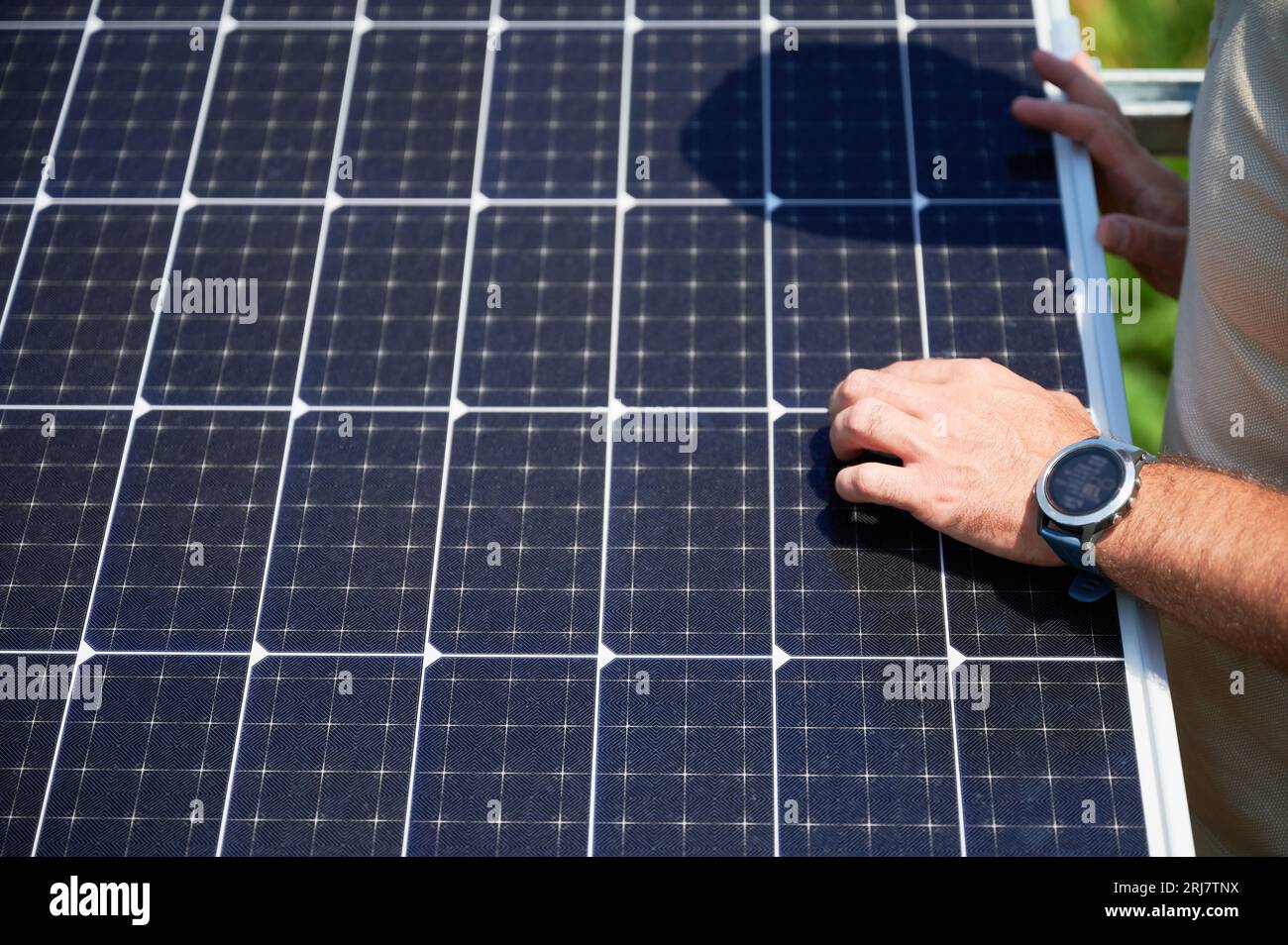Close up view of worker checking operation of PV solar cells. Male ...