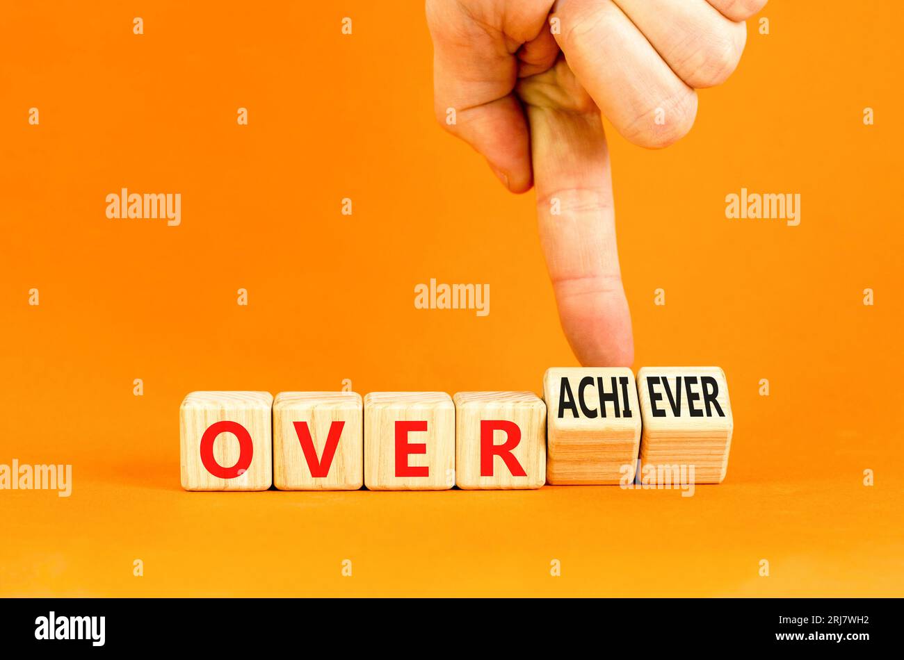 Achiever or overachiever symbol. Businessman turns wooden cubes and ...