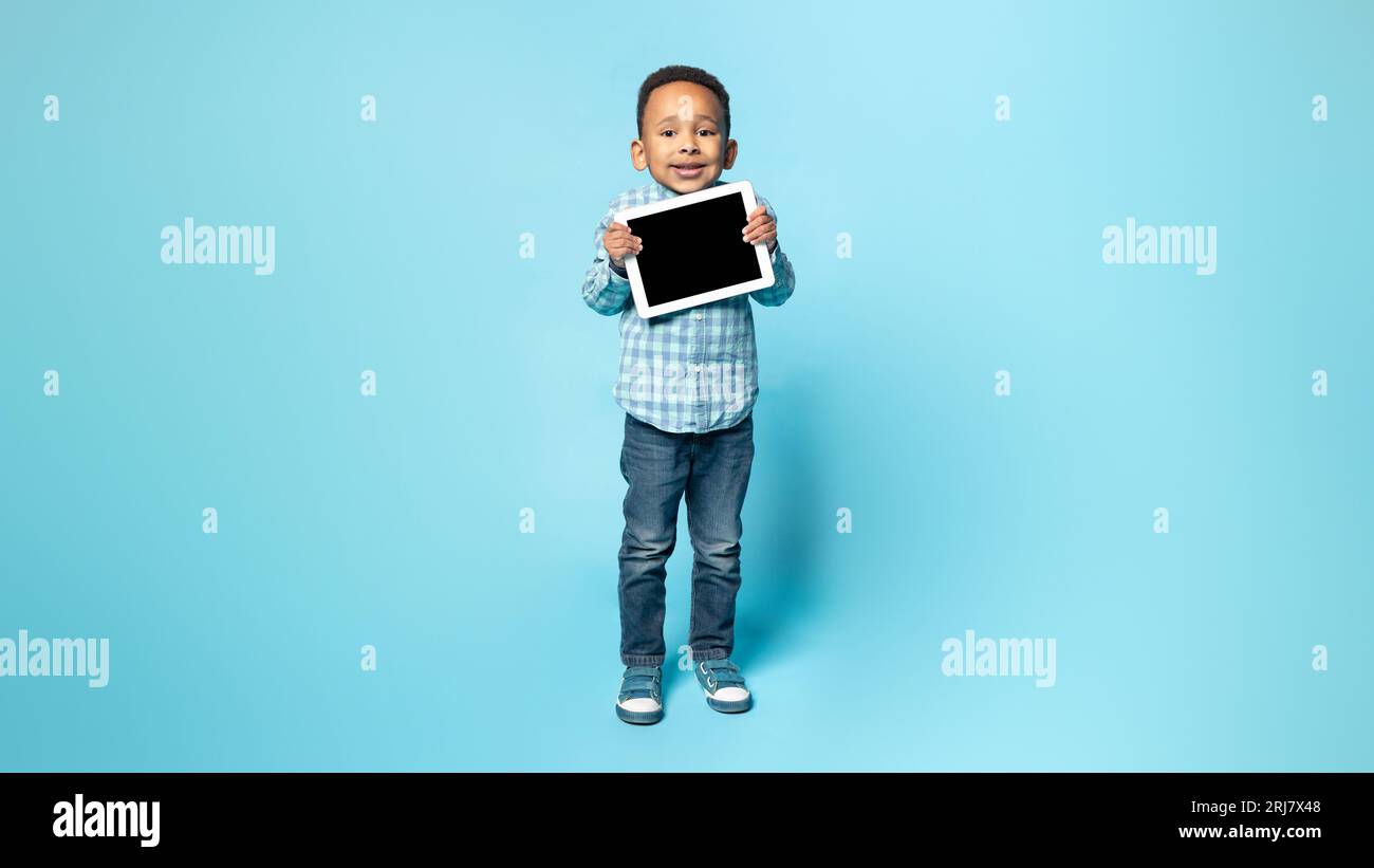 Cute african american little kid boy holding digital tablet with black ...