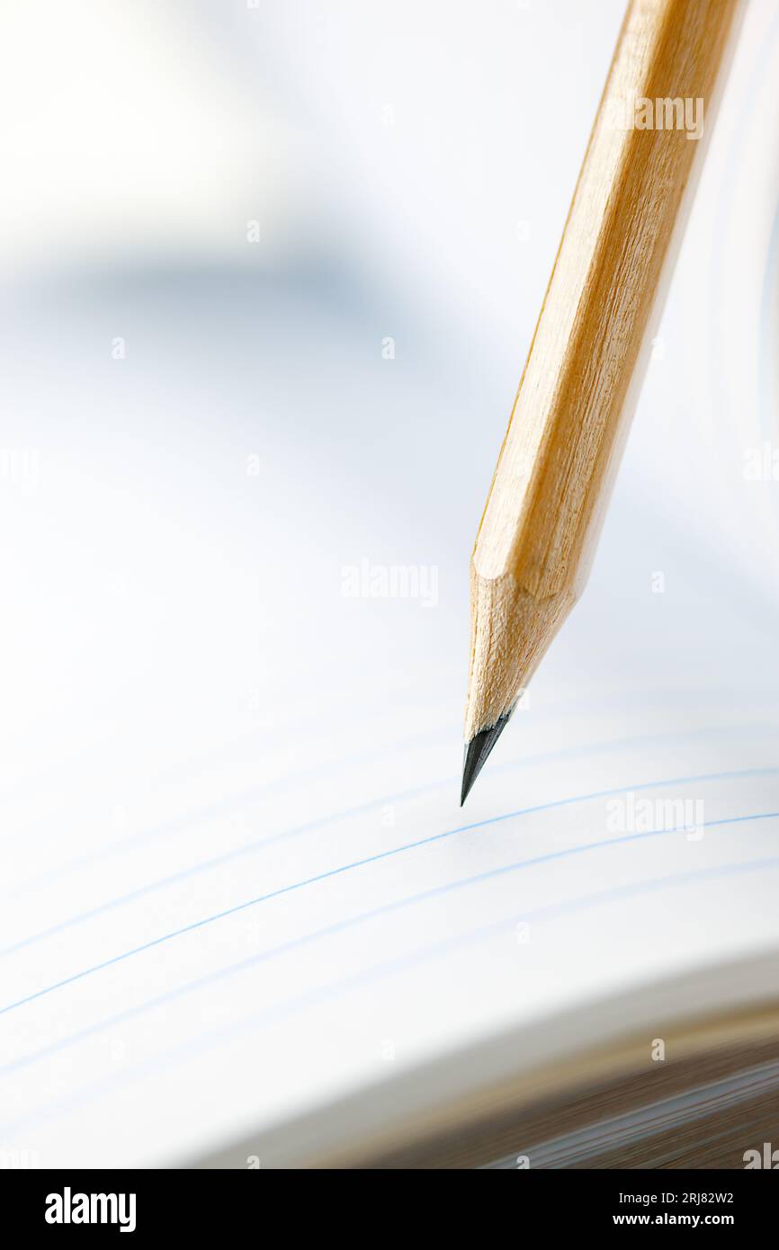 Closeup of sharp graphite pencil on white paper of notebook. Concept of ...