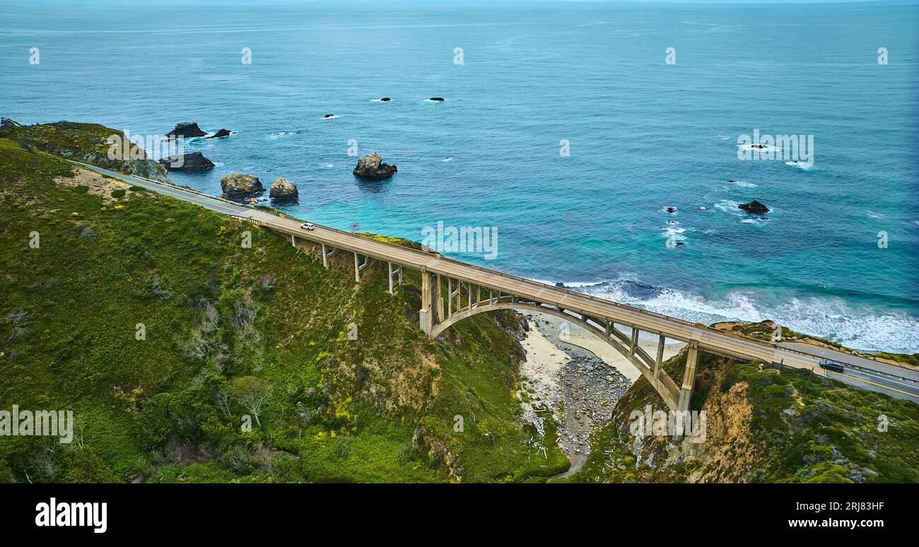 Aerial scenic view of Highway One Rocky Creek Bridge with ocean waves ...