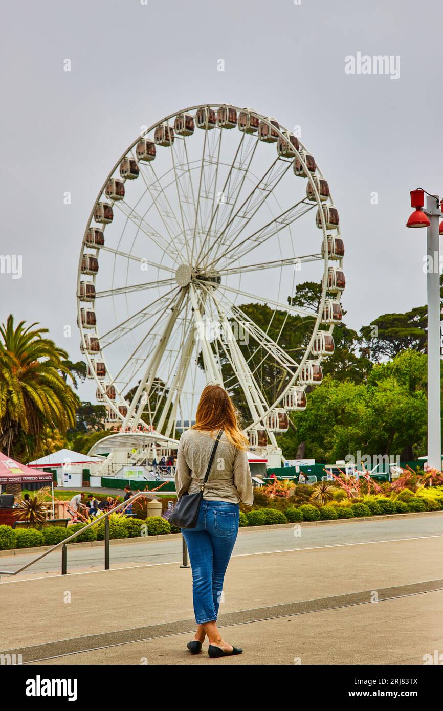 Woman in blue jeans and tan top with black purse looking at the SkyStar ...