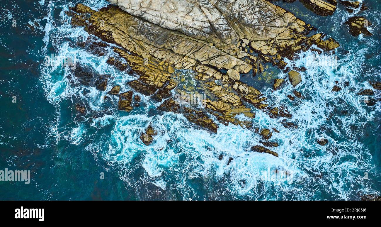 Aerial downward view of waves crashing against partially submerged ...