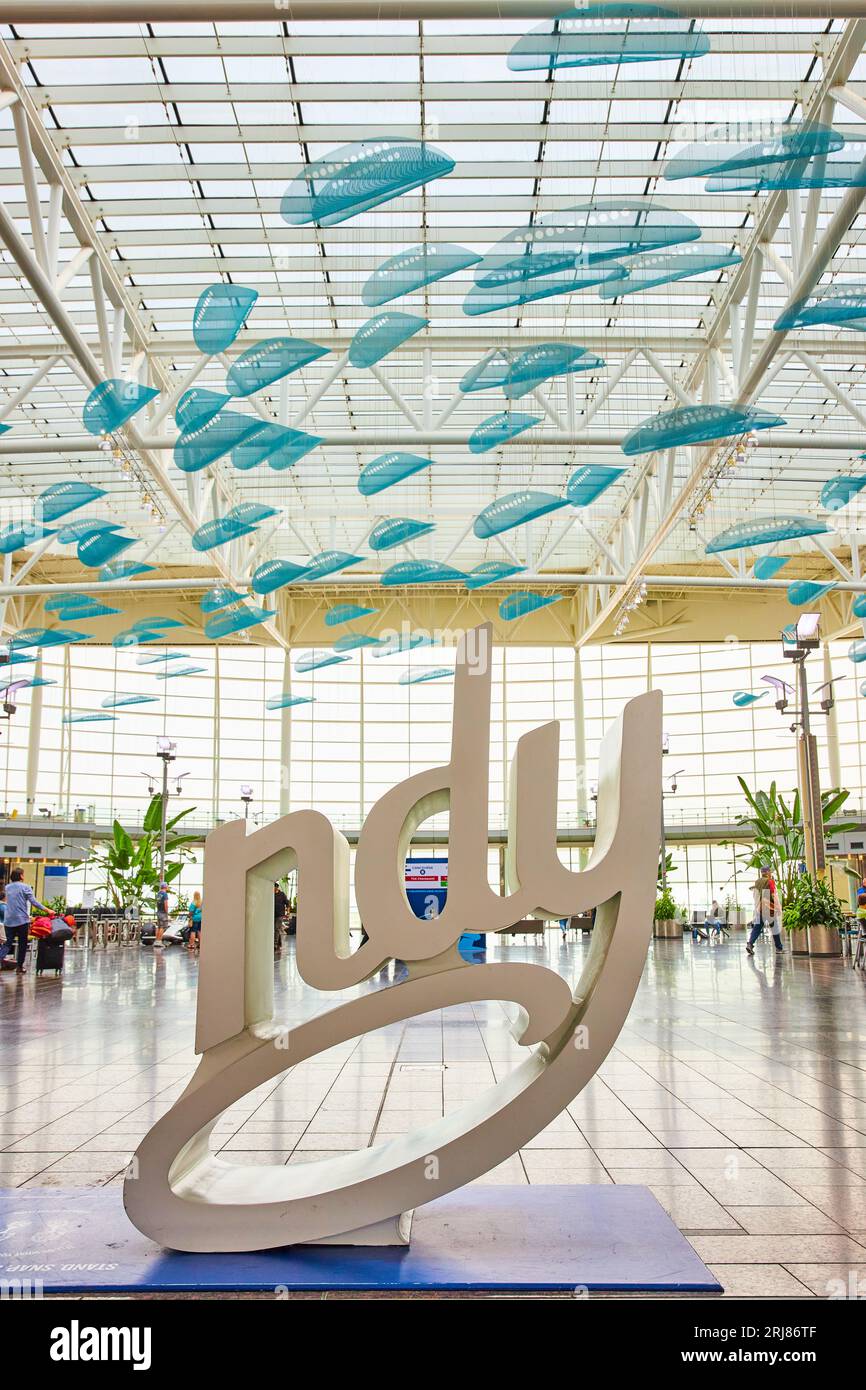 Indianapolis Ndy airport sign in lobby with hanging blue abstract art in curved shells under ...