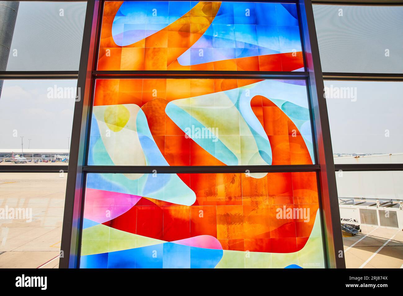 Vibrant colors in abstract window art with airport exterior visible ...