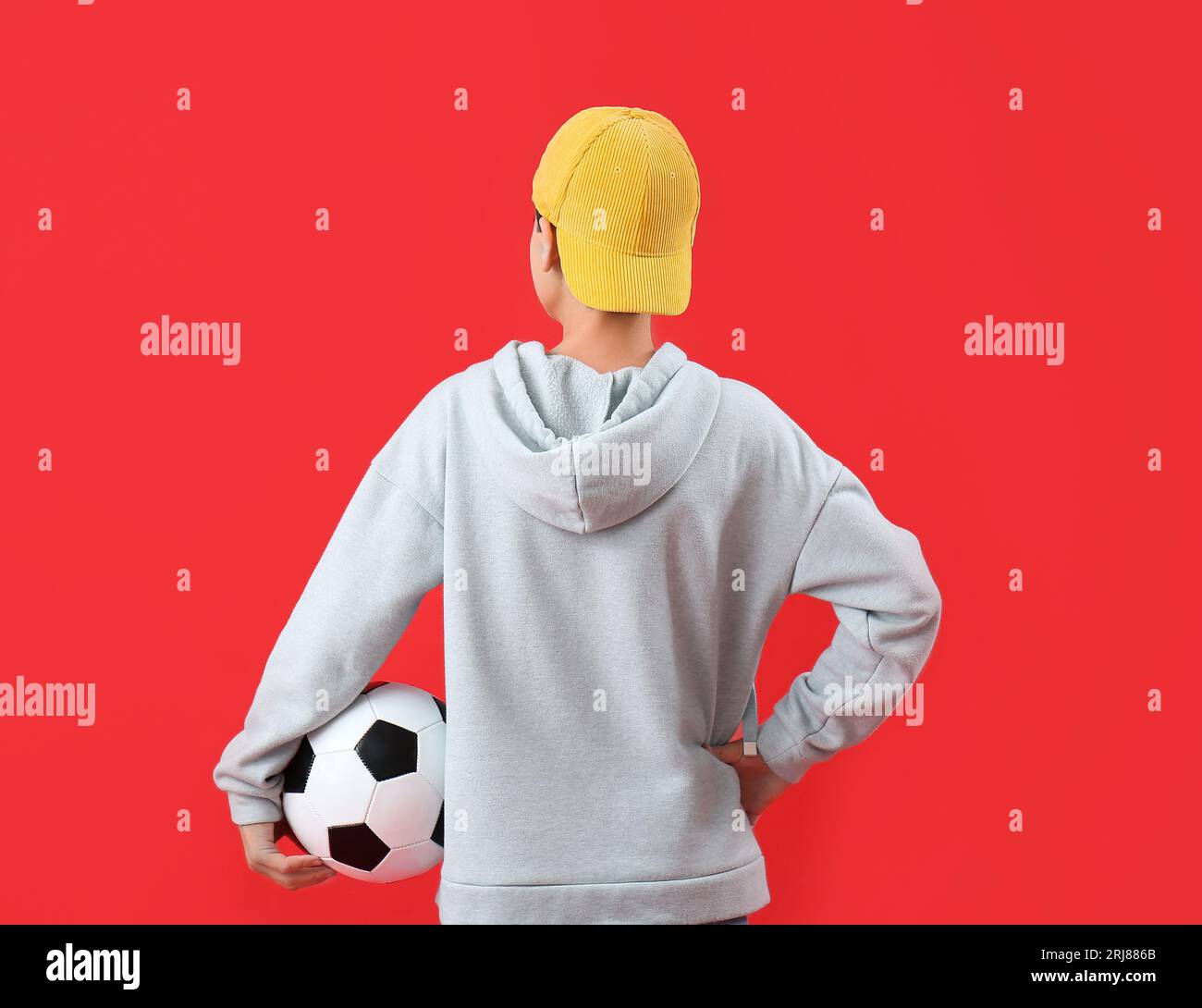 Little boy with soccer ball on red background, back view Stock Photo ...