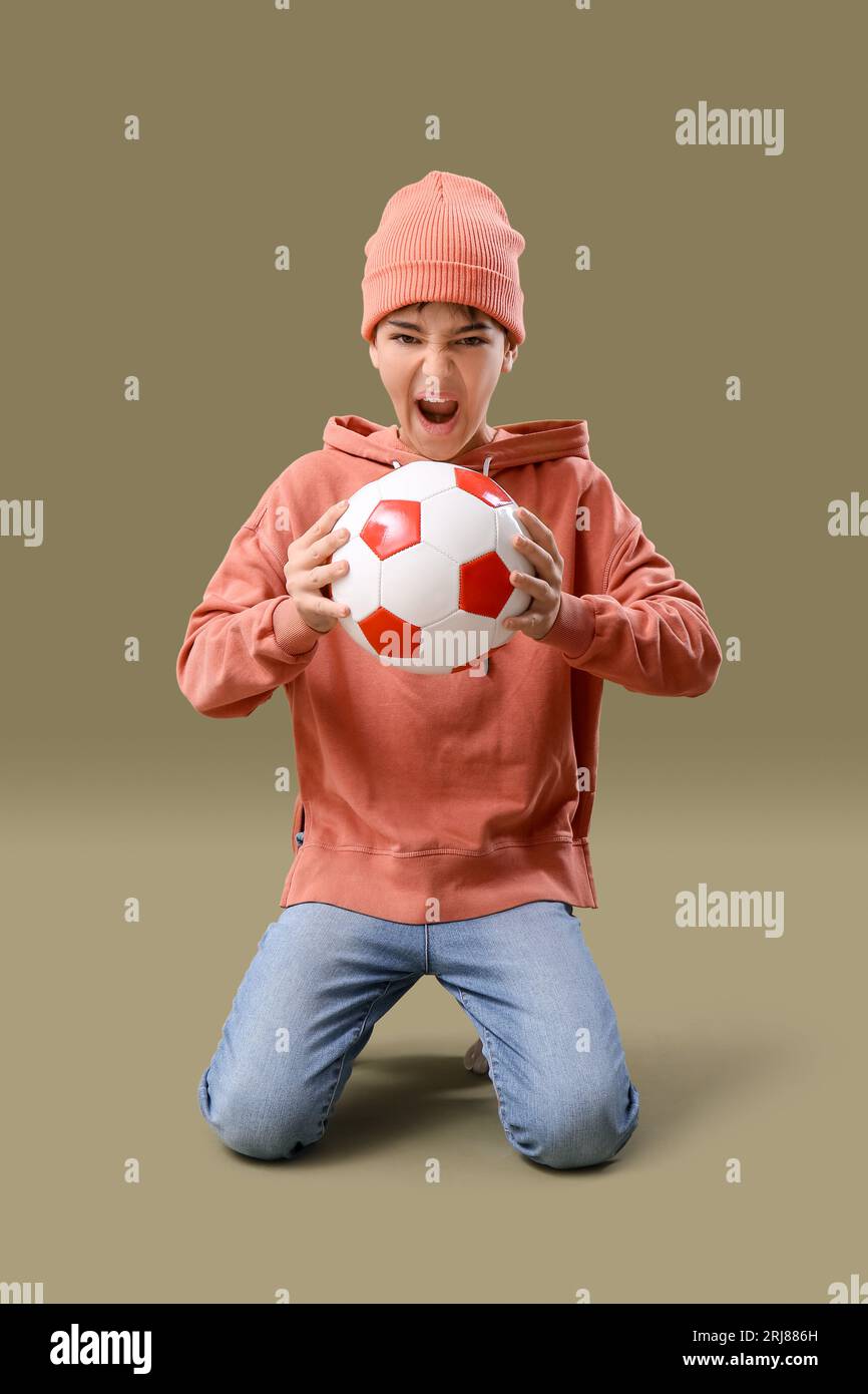Aggressive little boy with soccer ball on color background Stock Photo ...