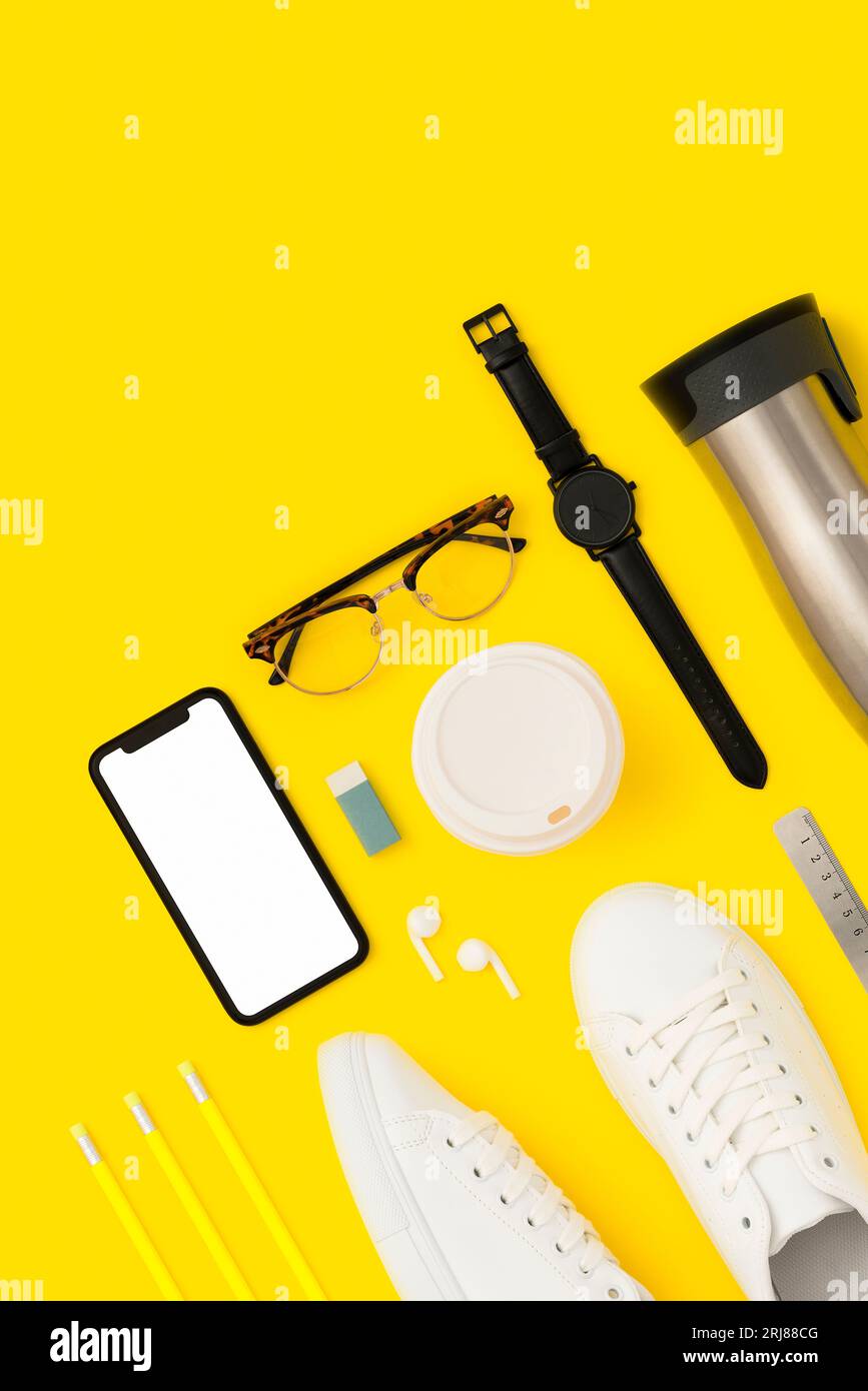 Back to school flat lay with smart phone mockup on yellow background ...