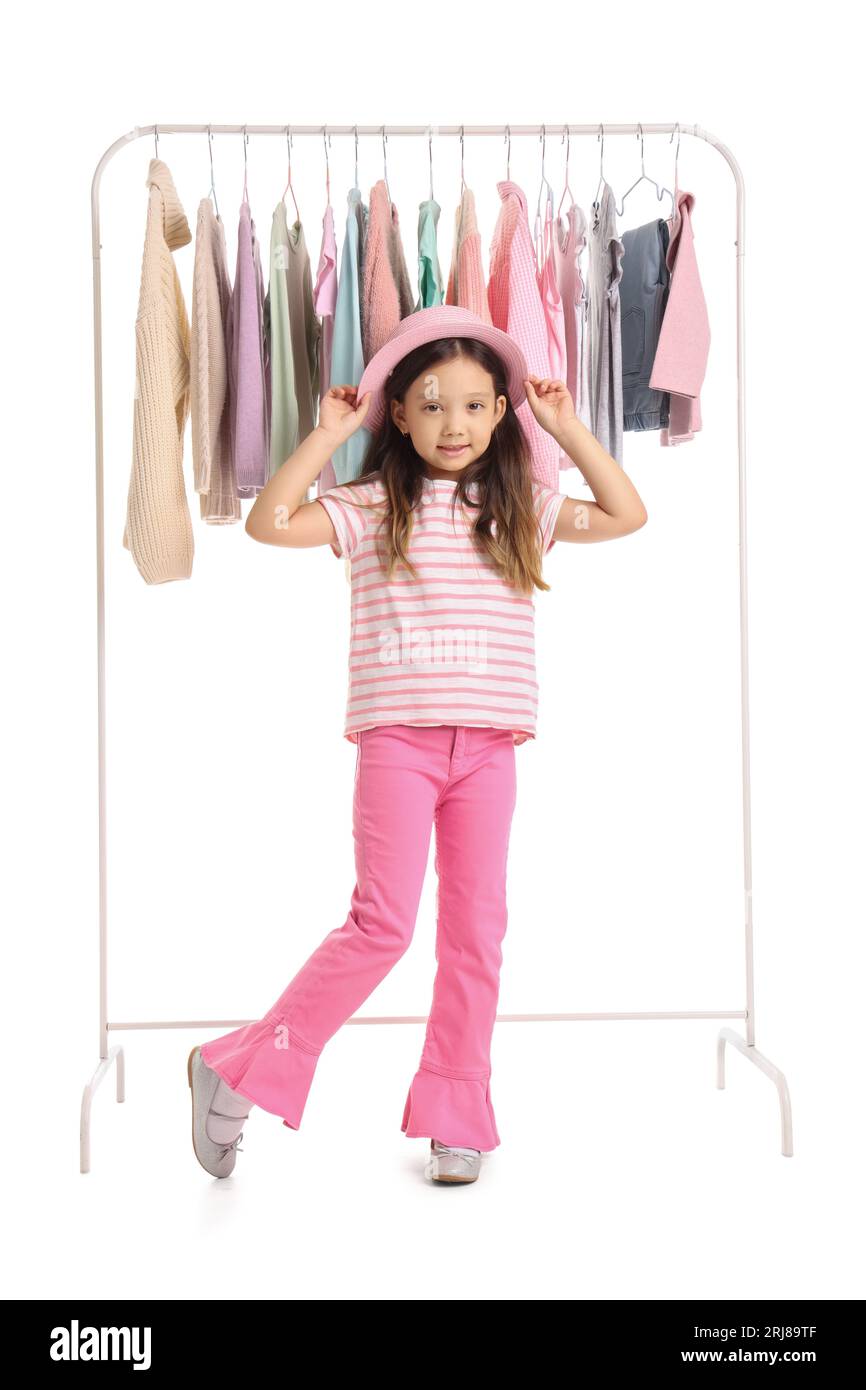 Cute little girl near rack with stylish clothes on white background ...
