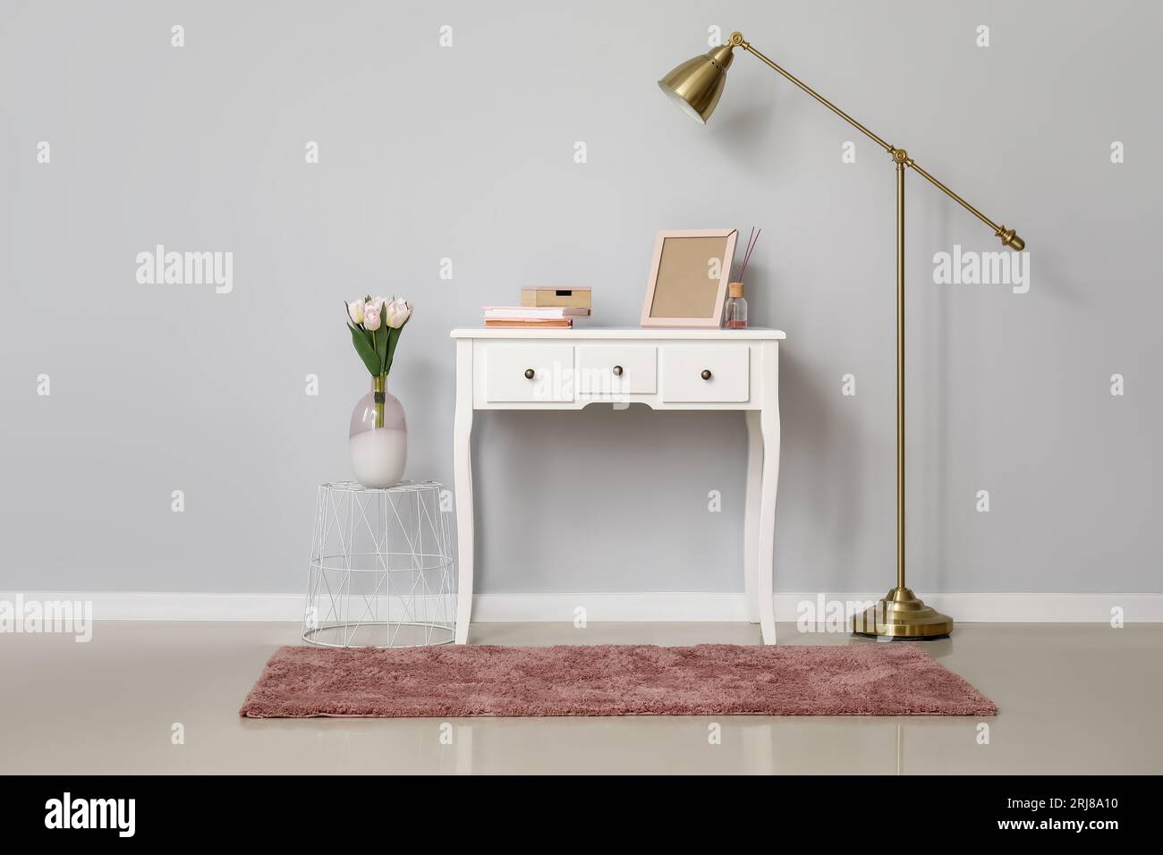 Standard lamp and dressing table near white wall Stock Photo - Alamy