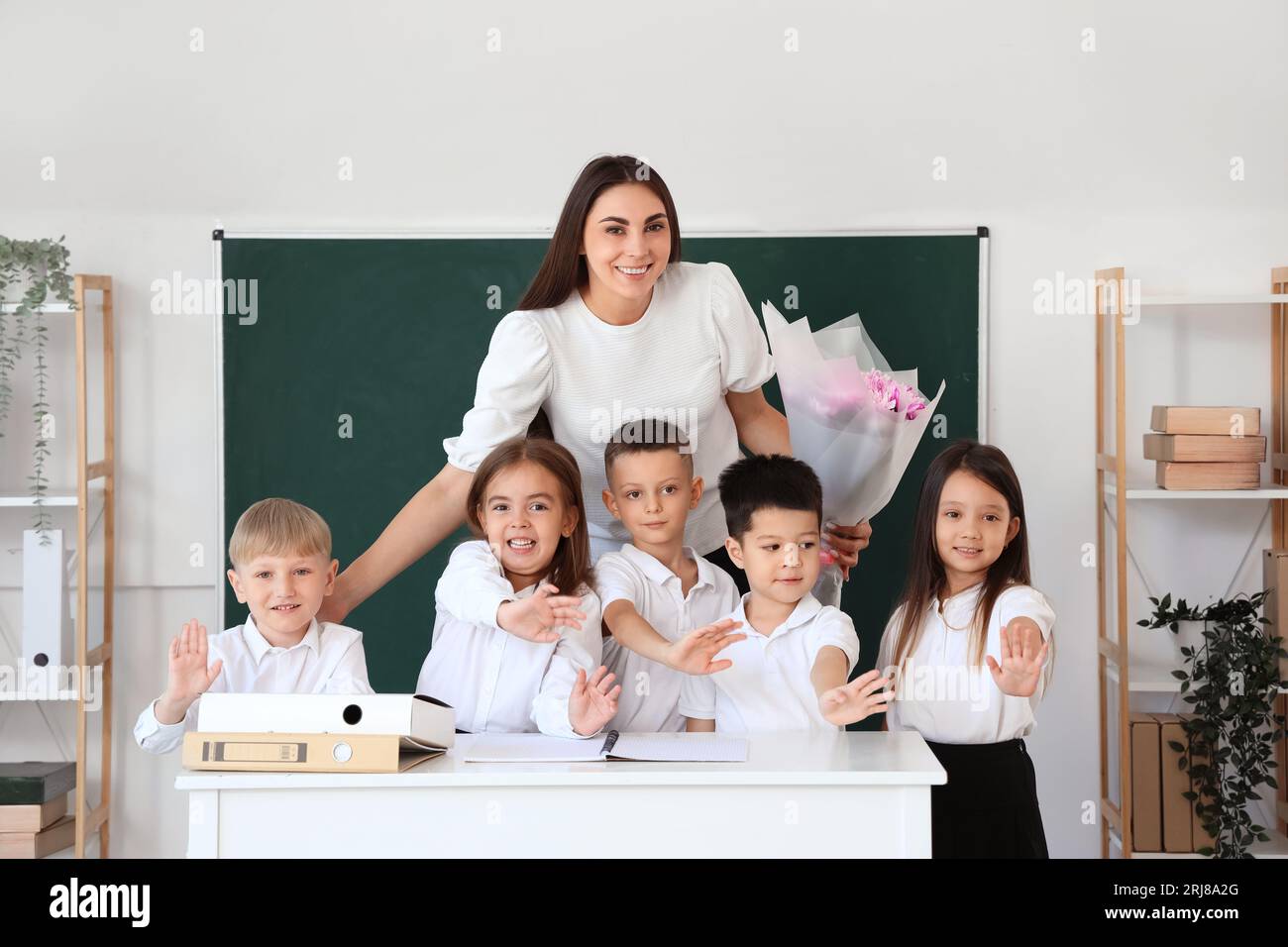 Female teacher with little school children in classroom Stock Photo - Alamy