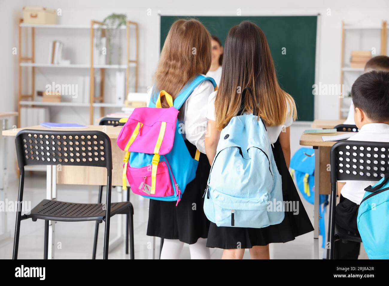 Little girls in classroom at school, back view Stock Photo - Alamy