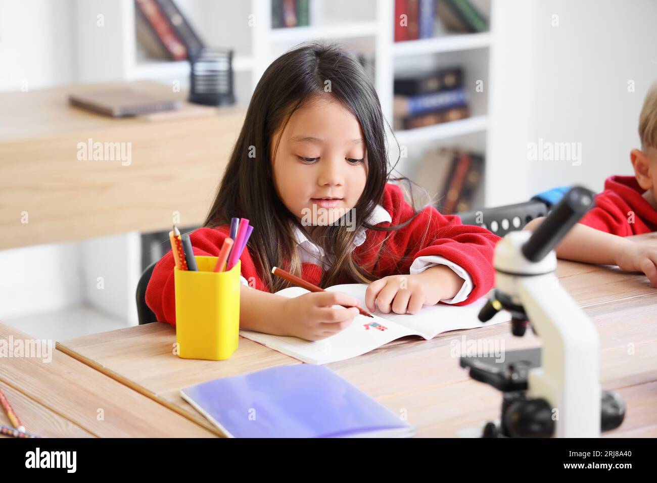Little school girl in classroom during lesson Stock Photo - Alamy