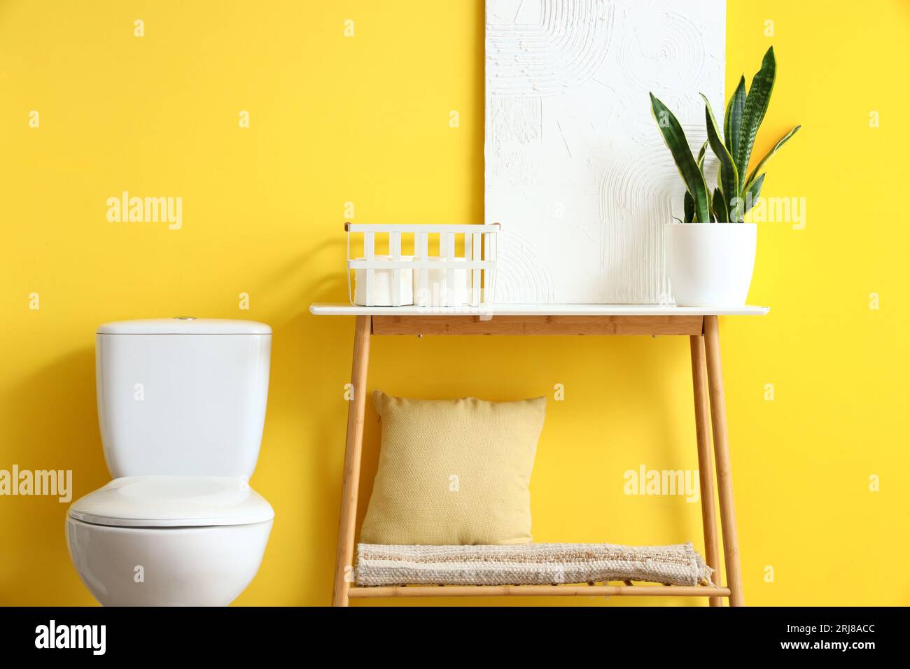 Interior of modern restroom with ceramic toilet bowl and console table ...